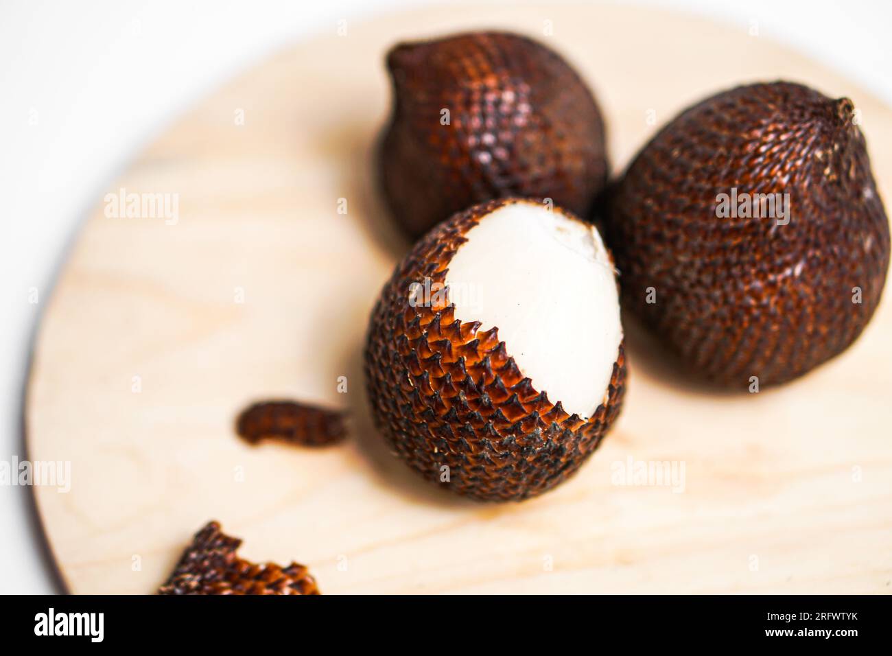 Salak or snake fruit in wooden plate isolated on white background Stock ...