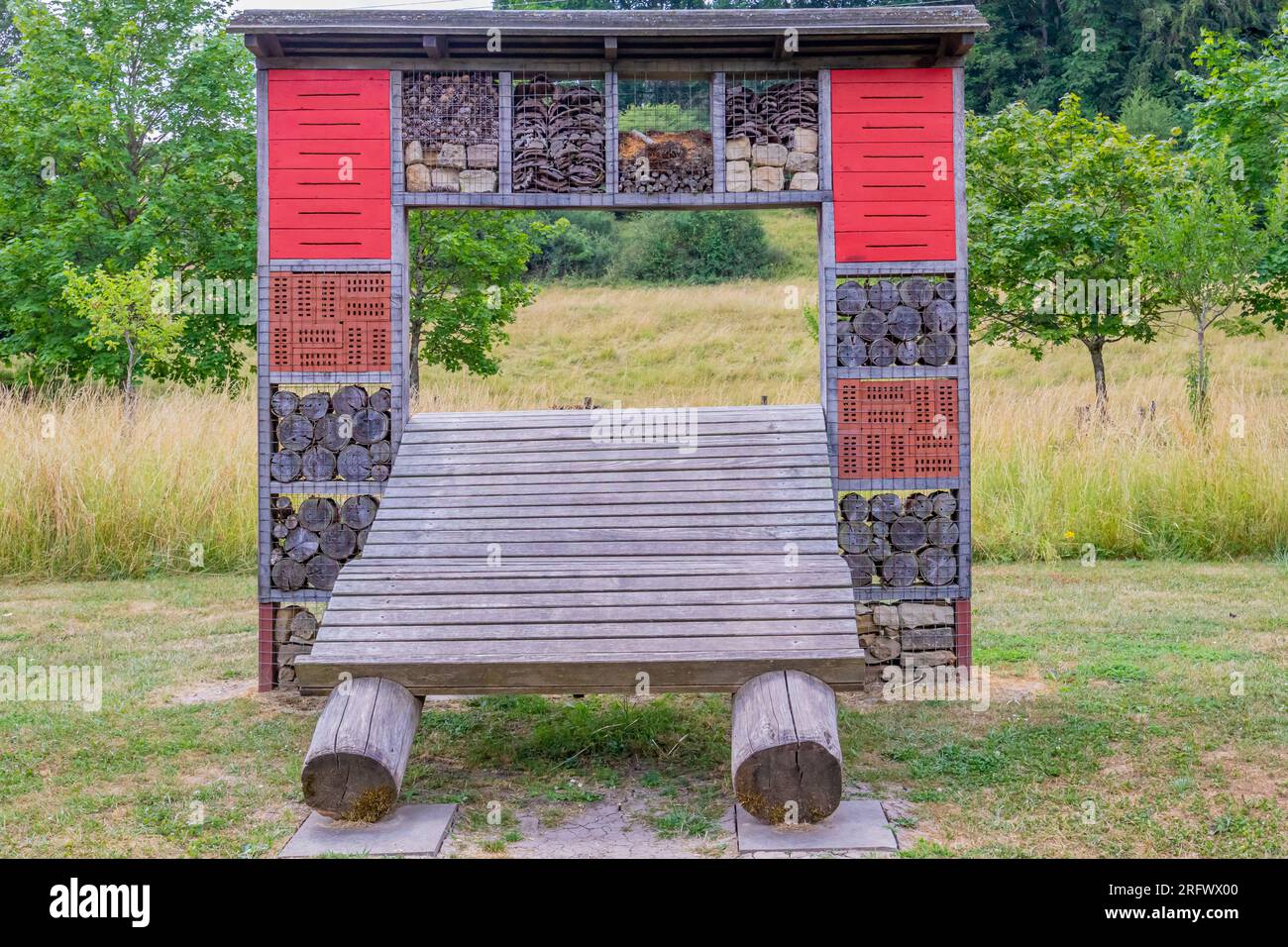 Insect hotel with various compartments, small sticks and logs with ...
