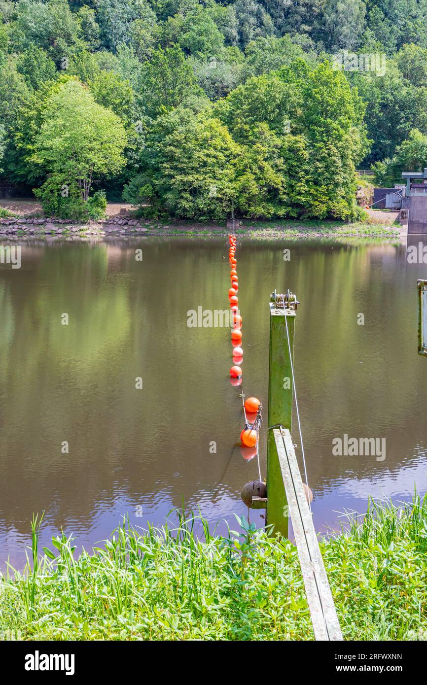 Orange buoys crossing river Prum near Staumauer dam at Stausee Bitburg ...