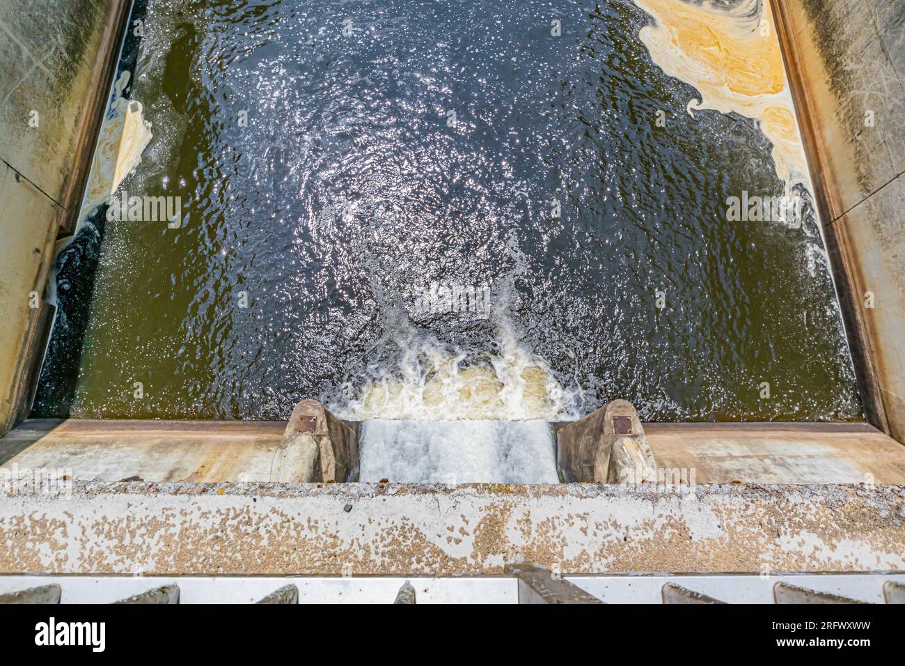 Gate of Staumauer Bitburger dam with water flowing out into Prum river ...