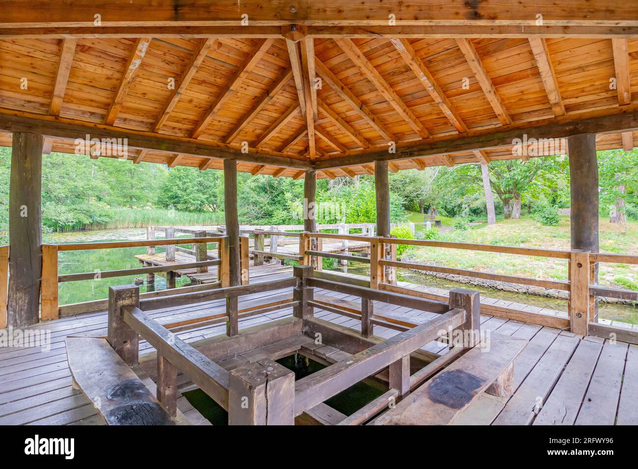 Old remodeled gazebo over a lake, wooden platform, fences, benches, and ...