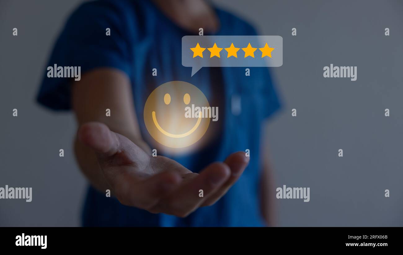 Businessman using a mobile phone to point to a smile face and five ...