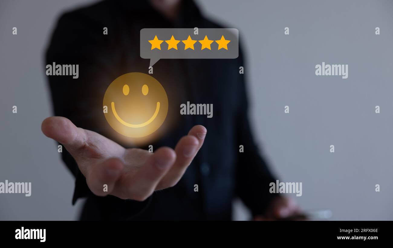 Businessman using a mobile phone to point to a smile face and five ...