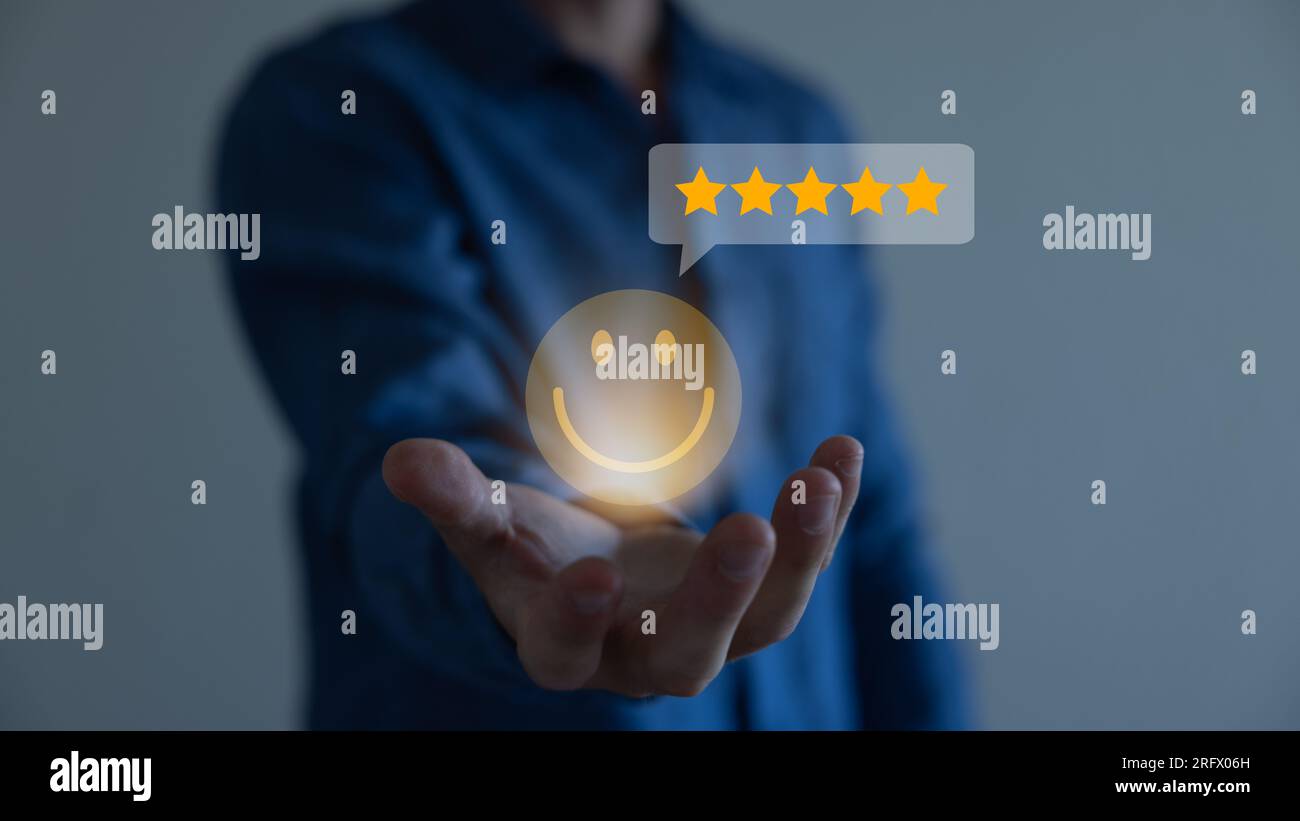 Businessman using a mobile phone to point to a smile face and five ...