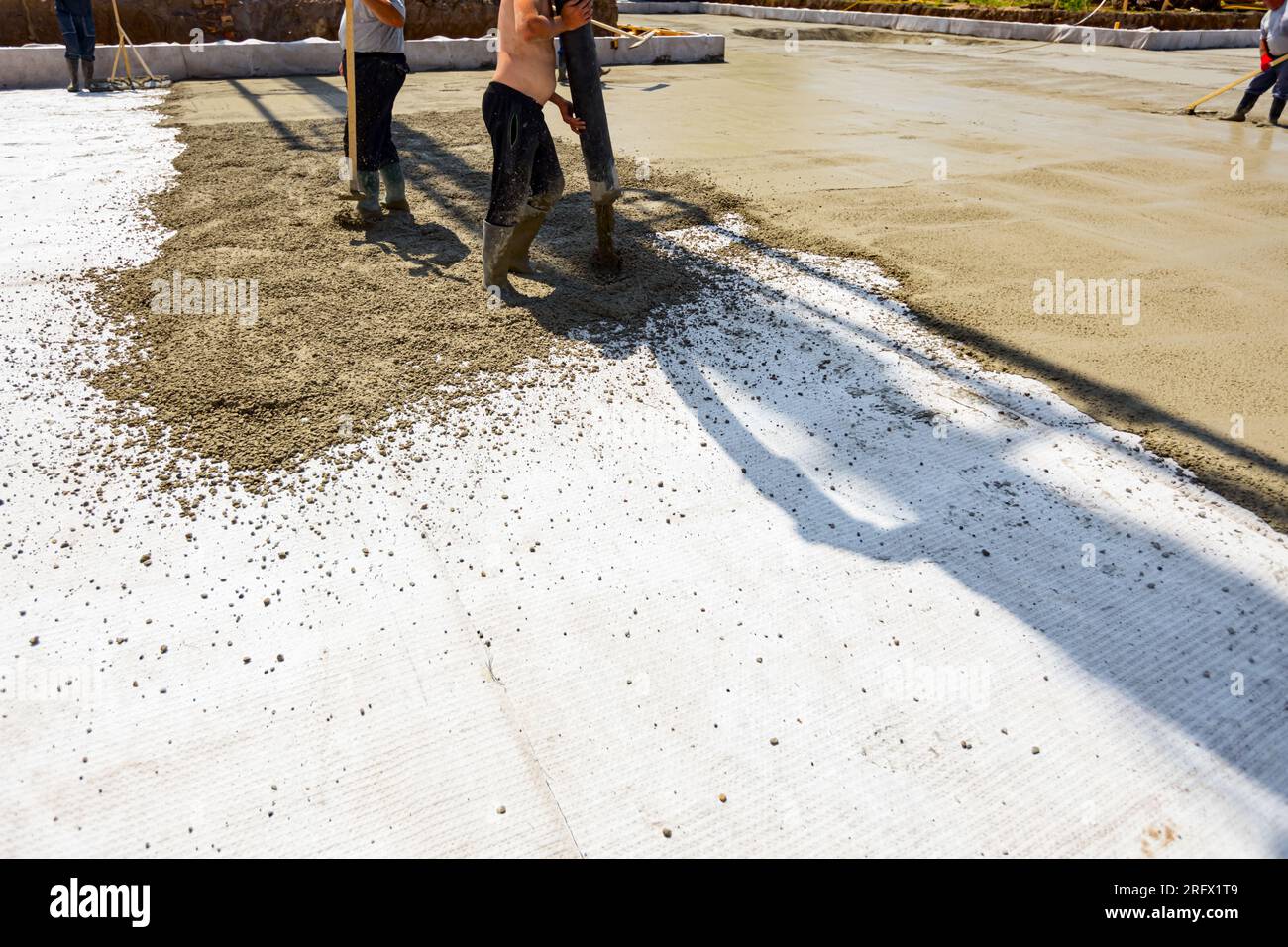 Construction worker is directing the pump tube on right direction ...