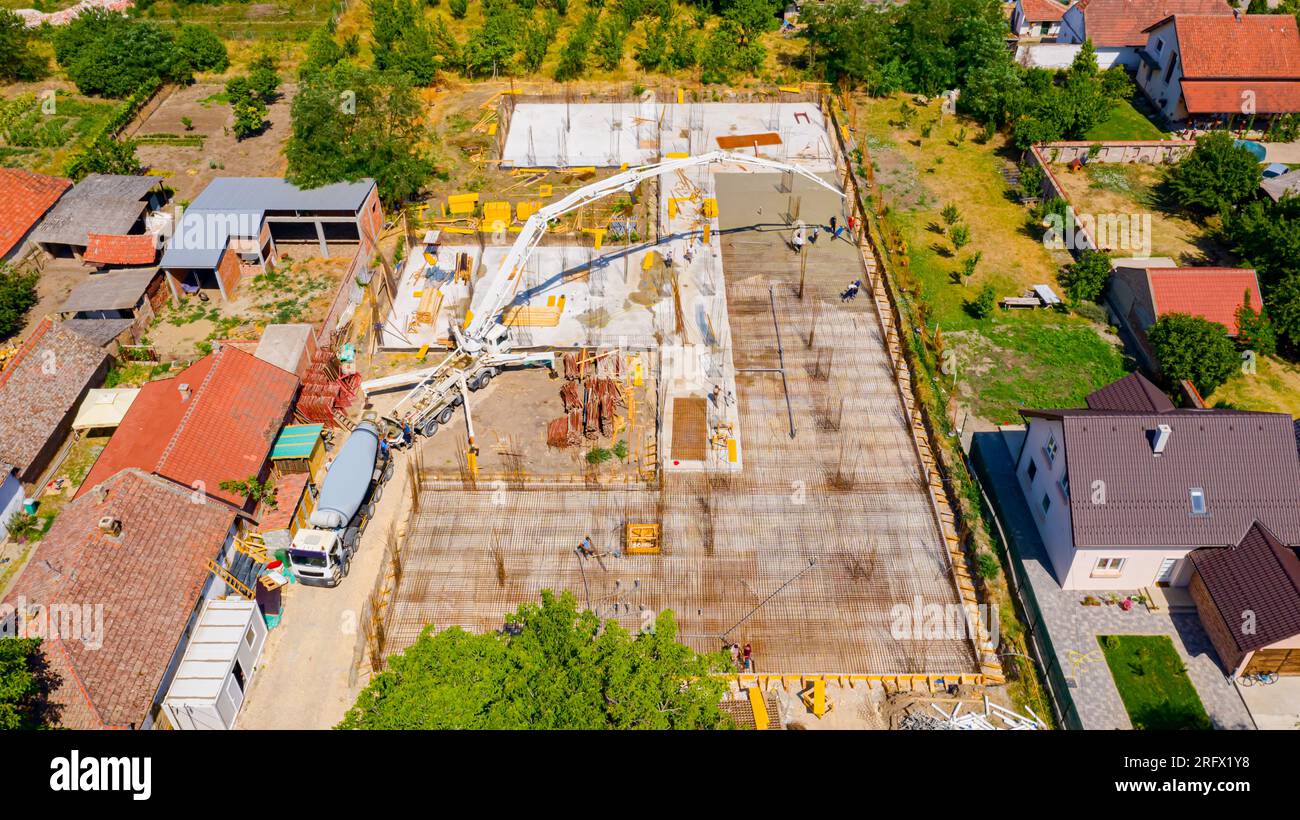Aerial view construction site, mixer truck pouring concrete into pump ...