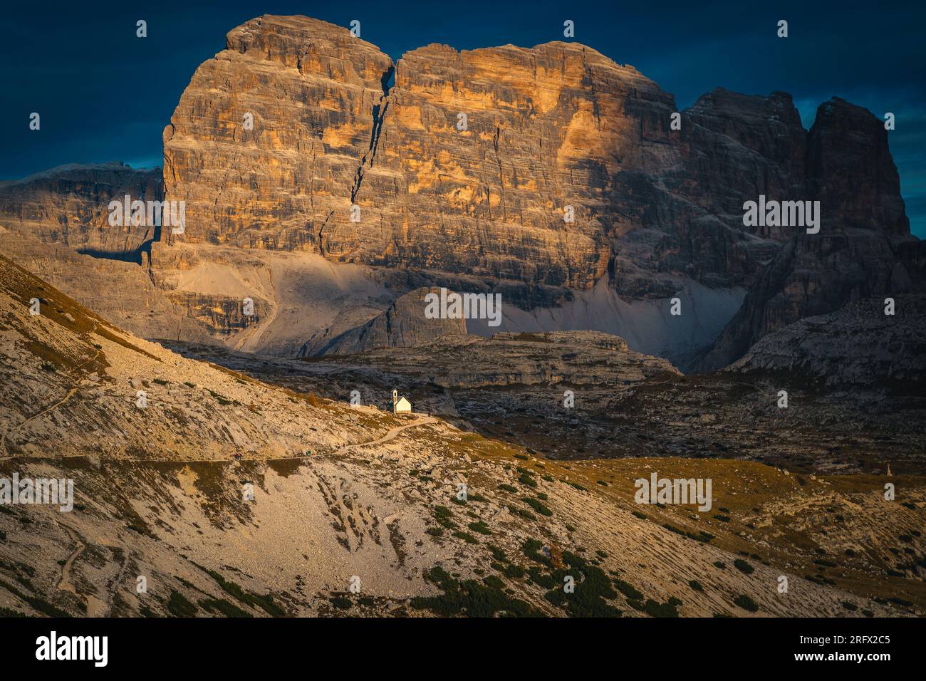 Cappella degli Alpini small chapel and beautiful high cliffs at sunset ...