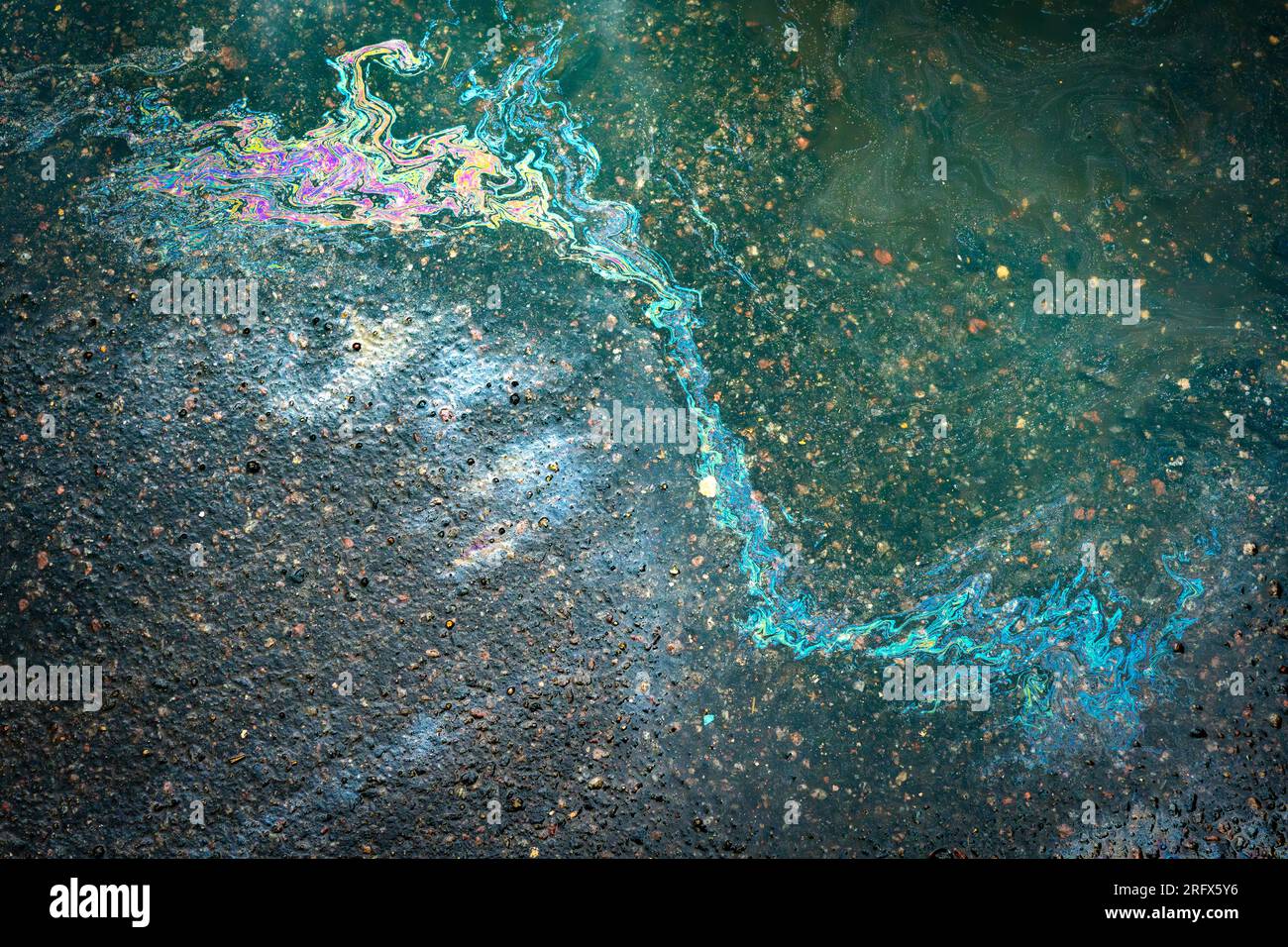 Oil after rain makes spots with rainbow reflections refractive sun ...