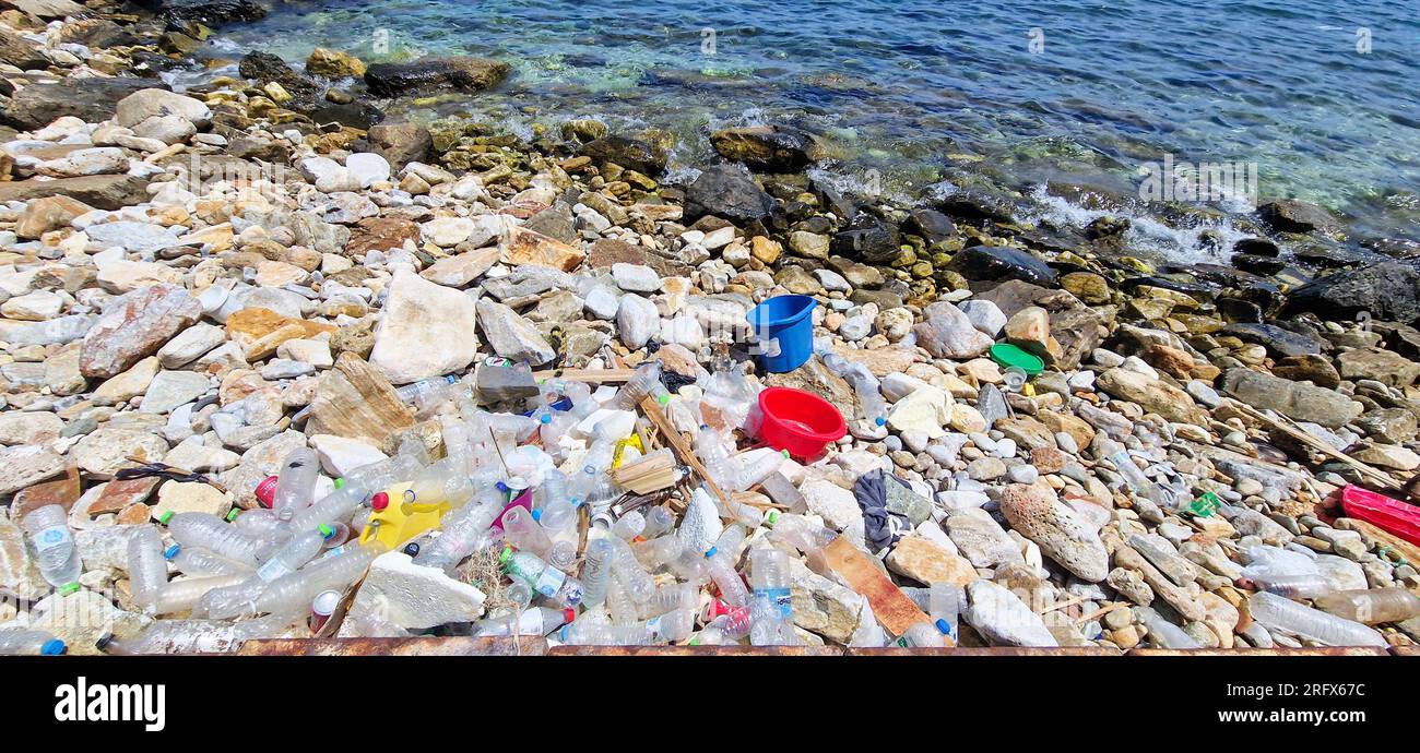 Dozen of plastic bottles and plastic waste lay along the sea shore ...