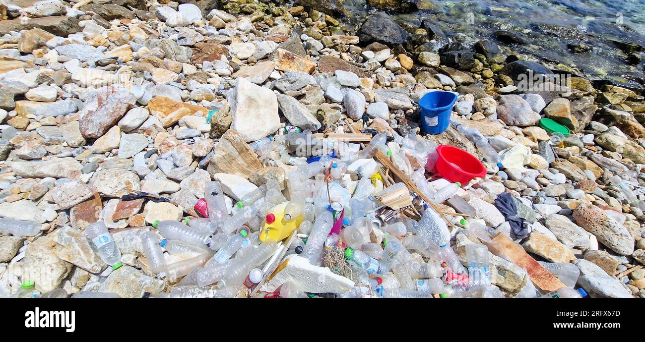 Dozen of plastic bottles and plastic waste lay along the sea shore ...