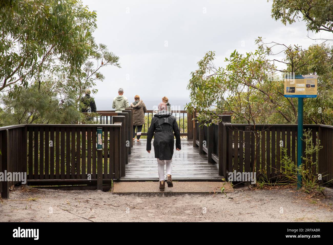 Fraser Island visitors stand on a viewing platform to see Lake Wabby ...