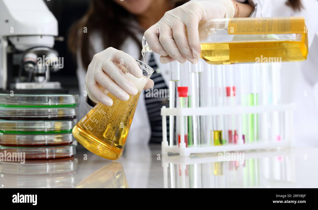 Scientist making mixture of fluid for experiment Stock Photo - Alamy