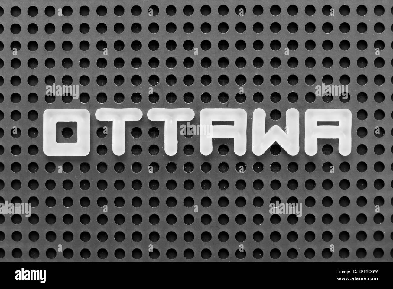 White alphabet letter in word ottawa on black pegboard background Stock ...