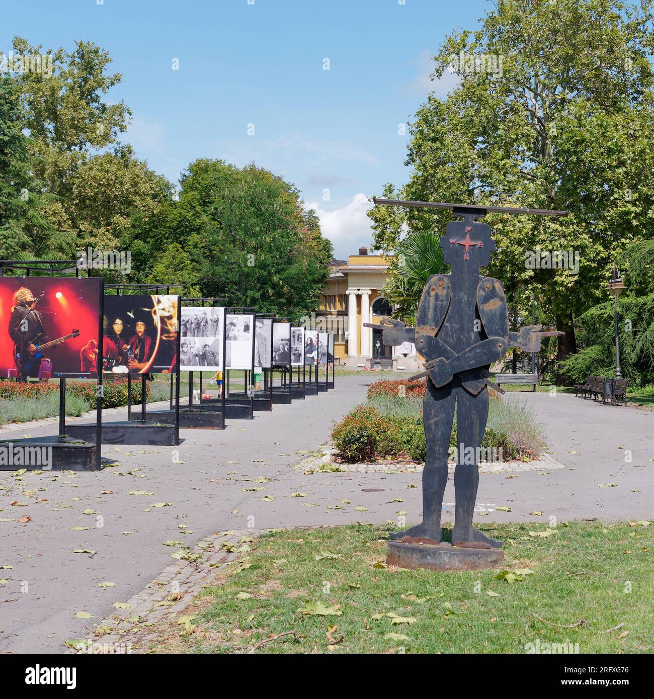 Metal statue with compass markings outside a concert venue within ...