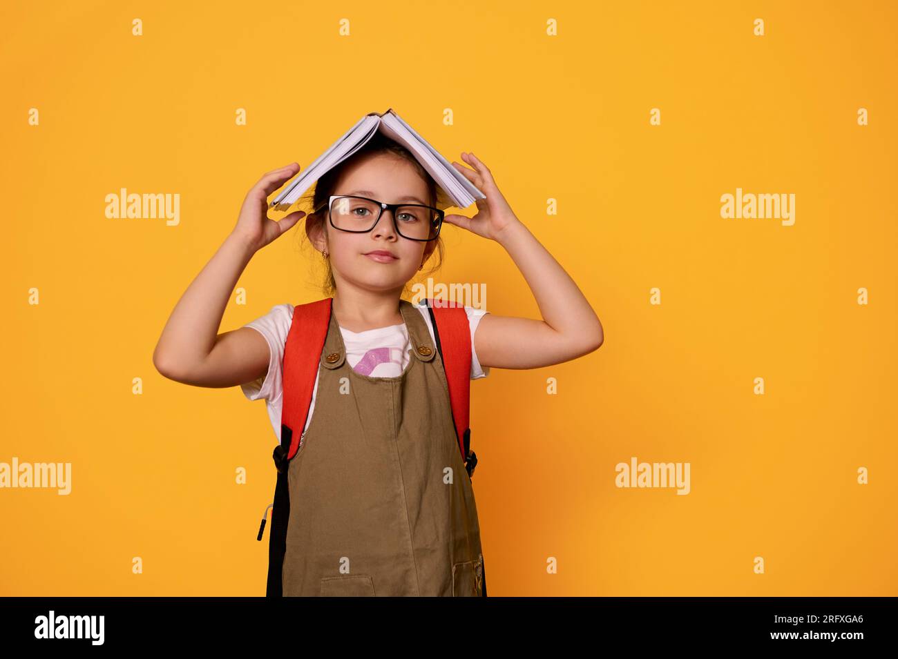 Caucasian lovely kid girl in casual dress and stylish eyeglasses ...