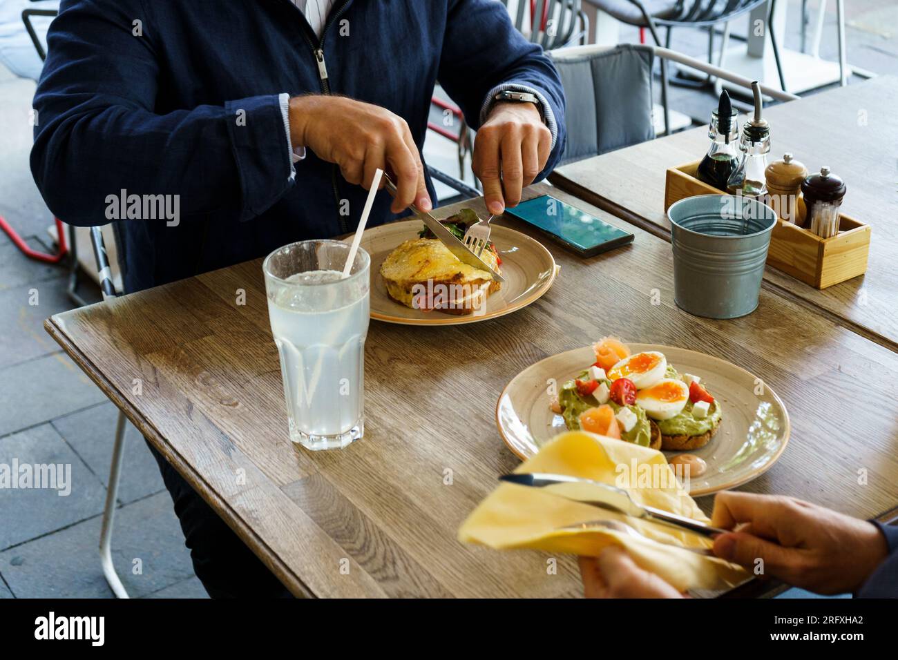 Two people eating breakfast dishes, Classic french toast with cheese ...
