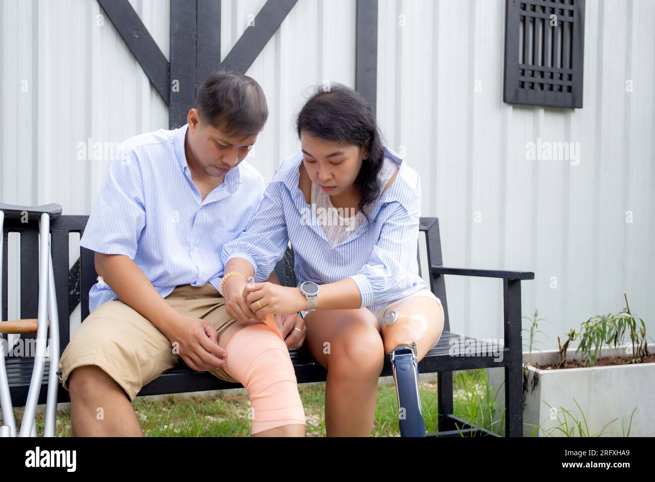 Young asian couple disabled take care while woman applying bandage with ...