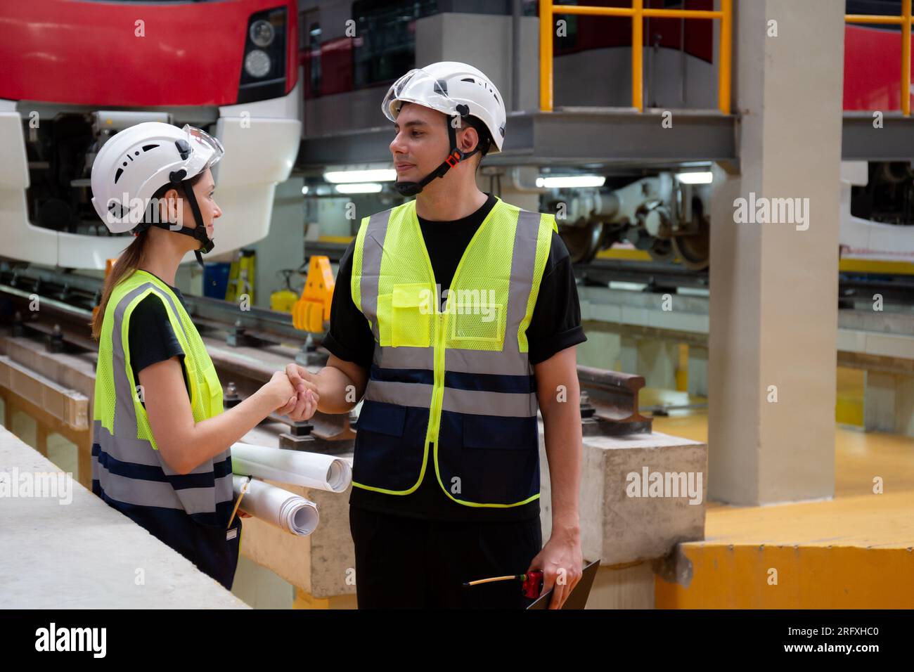 Young caucasian engineer man and woman hold blueprint meeting and ...
