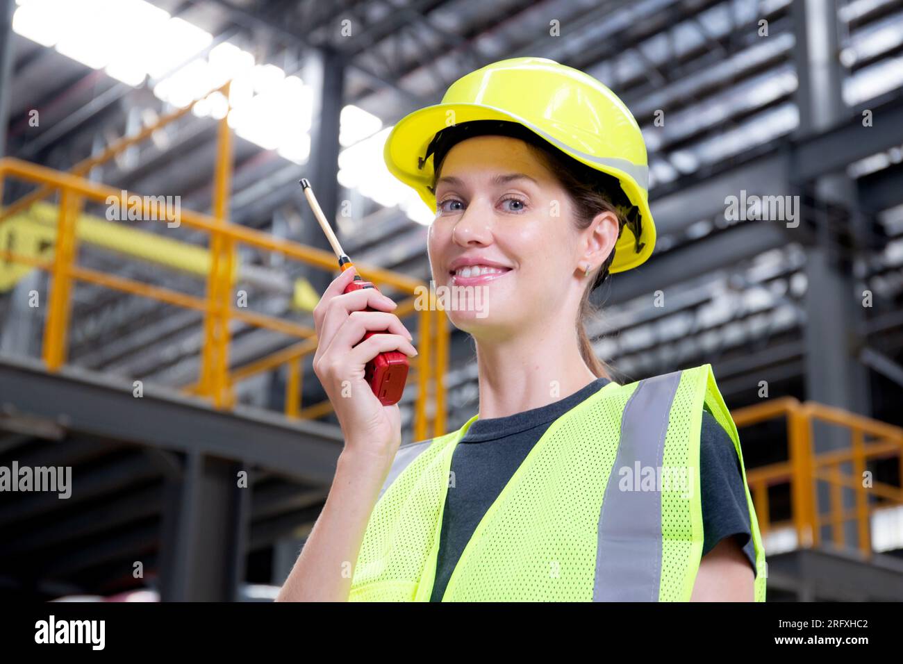 Young caucasian engineer woman using radio for command with worker ...