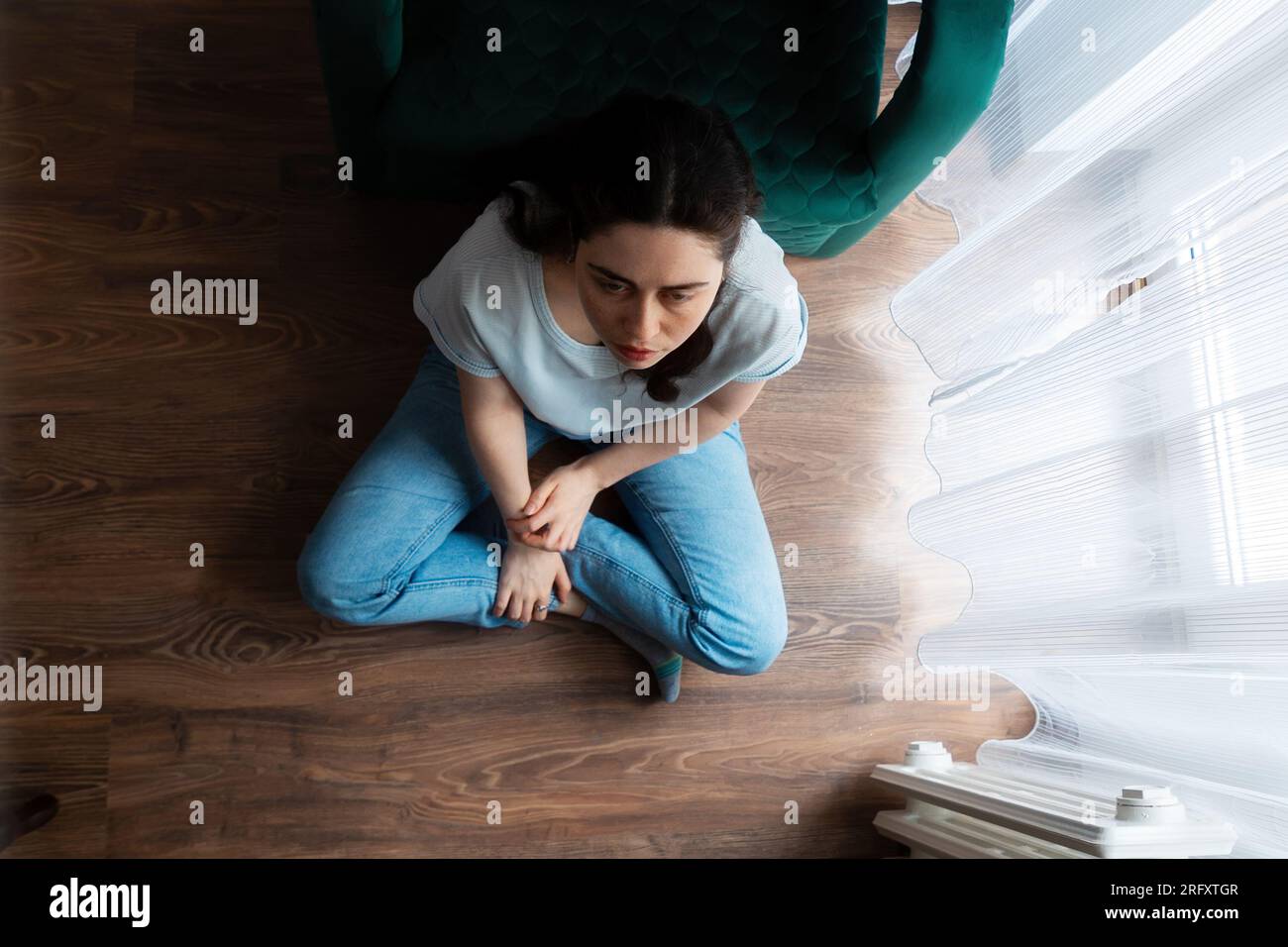 View from above at depressed Caucasian young woman sitting crossed legs ...