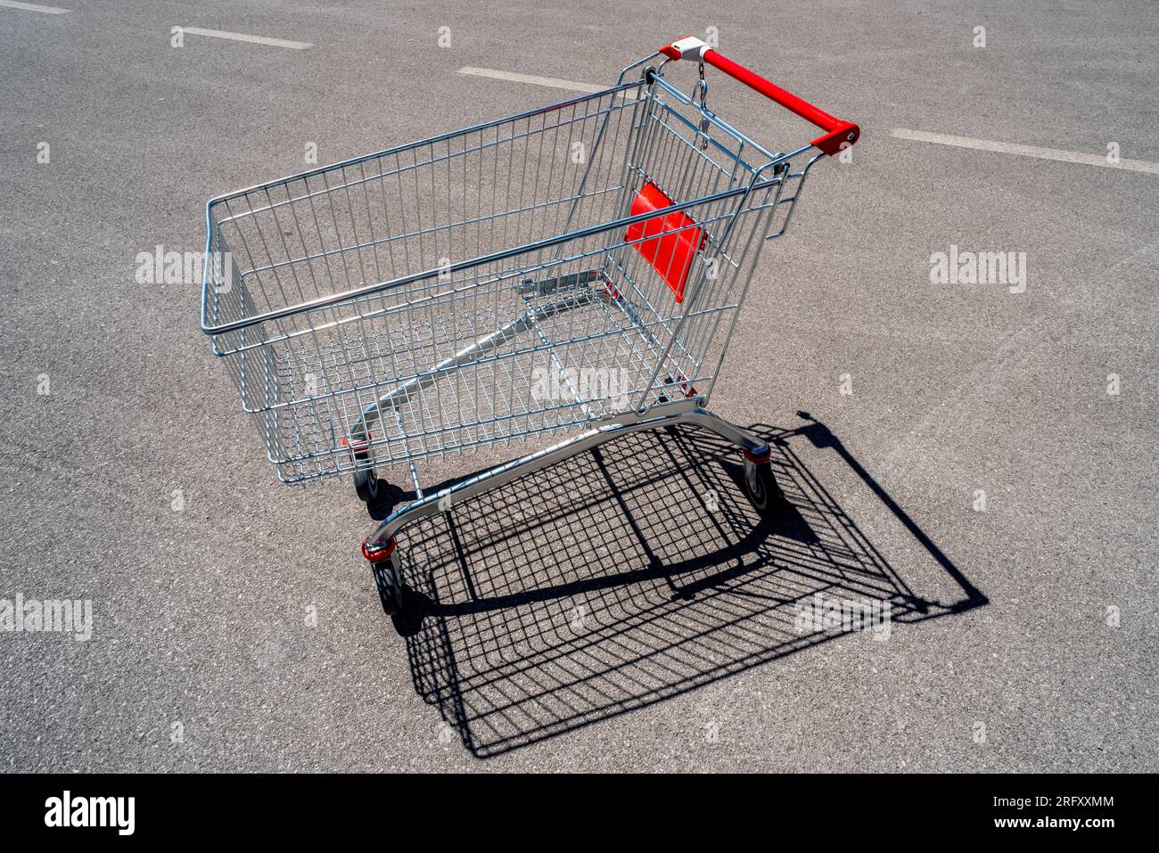 Empty shopping trolley with shade outside on paved square Stock Photo ...