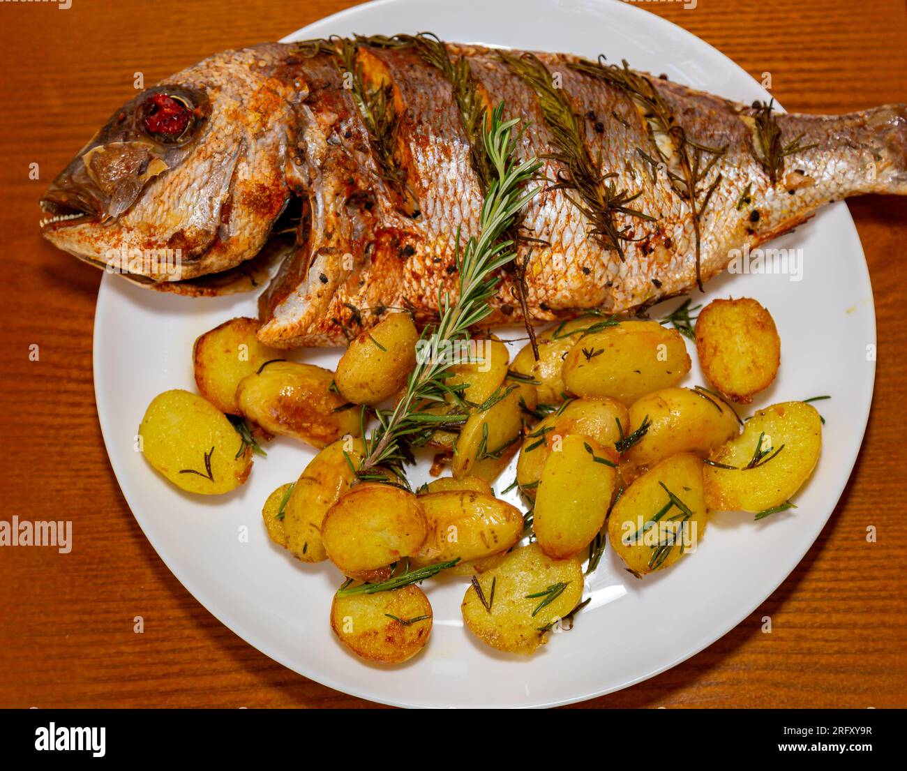 Traditional roast snapper fish with rosemary and sautéed potatoes Stock ...
