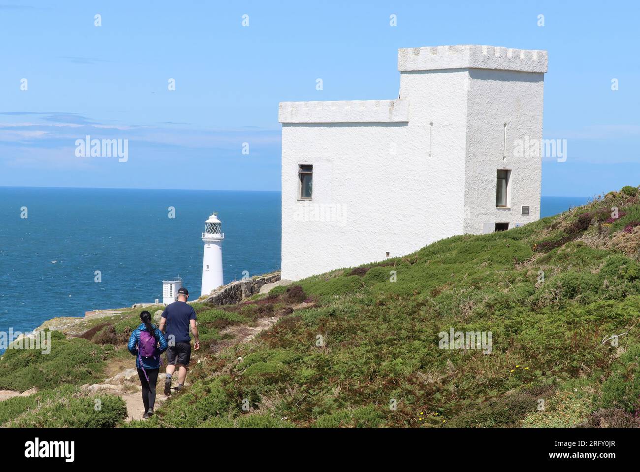 Walkers on the Anglesey Coastal Path near Elin's Tower (Tŵr Elin), with ...