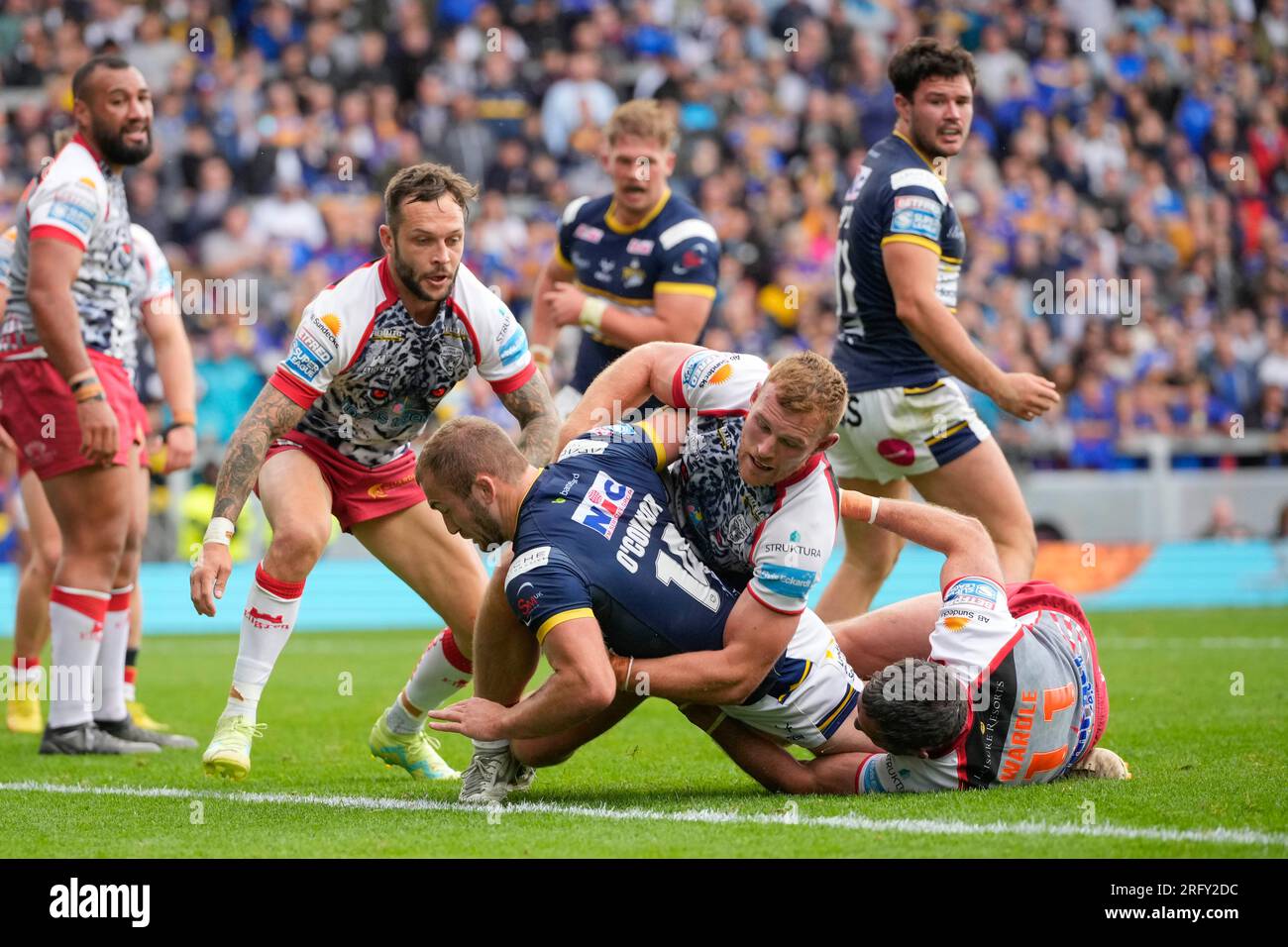 Jarrod O’Connor #14 of Leeds Rhinos drives through the tackle of Joe ...