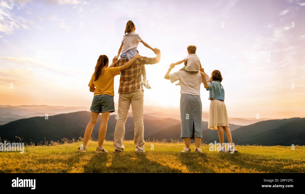 Happy family at sunset. Father, mother and children are enjoying summer ...