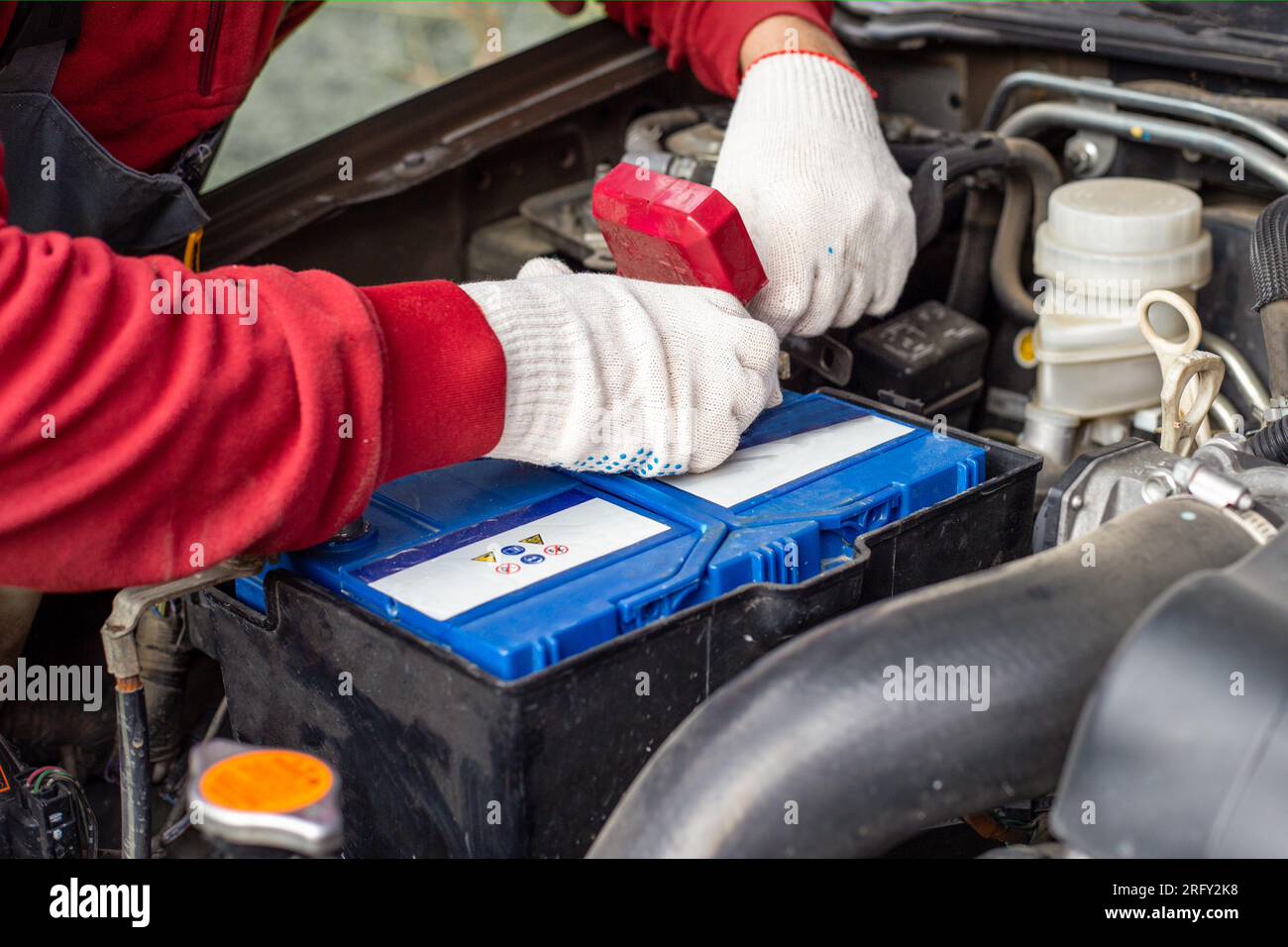 a car mechanic installs a battery in a car. Battery replacement and ...