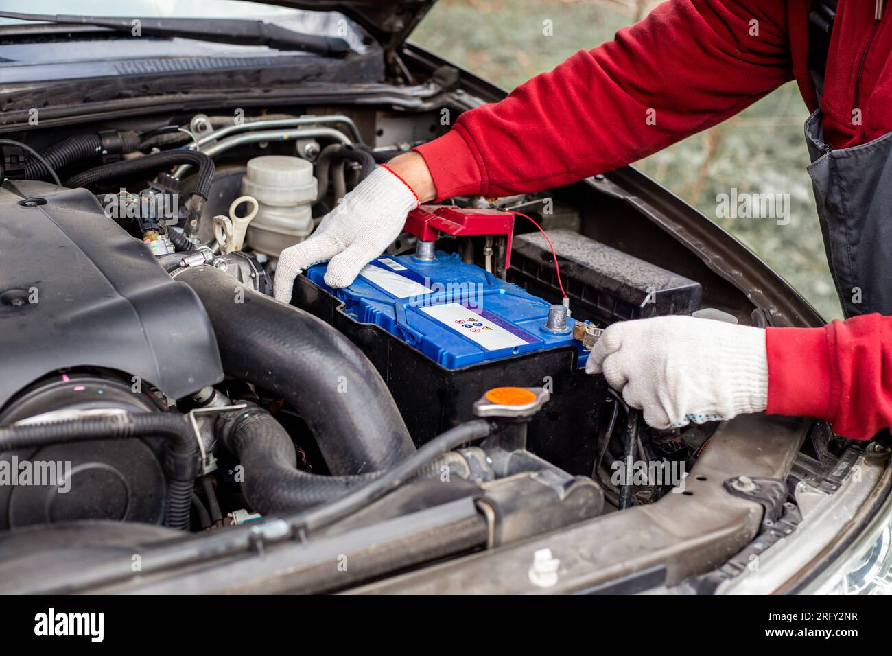 a car mechanic installs a battery in a car. Battery replacement and ...