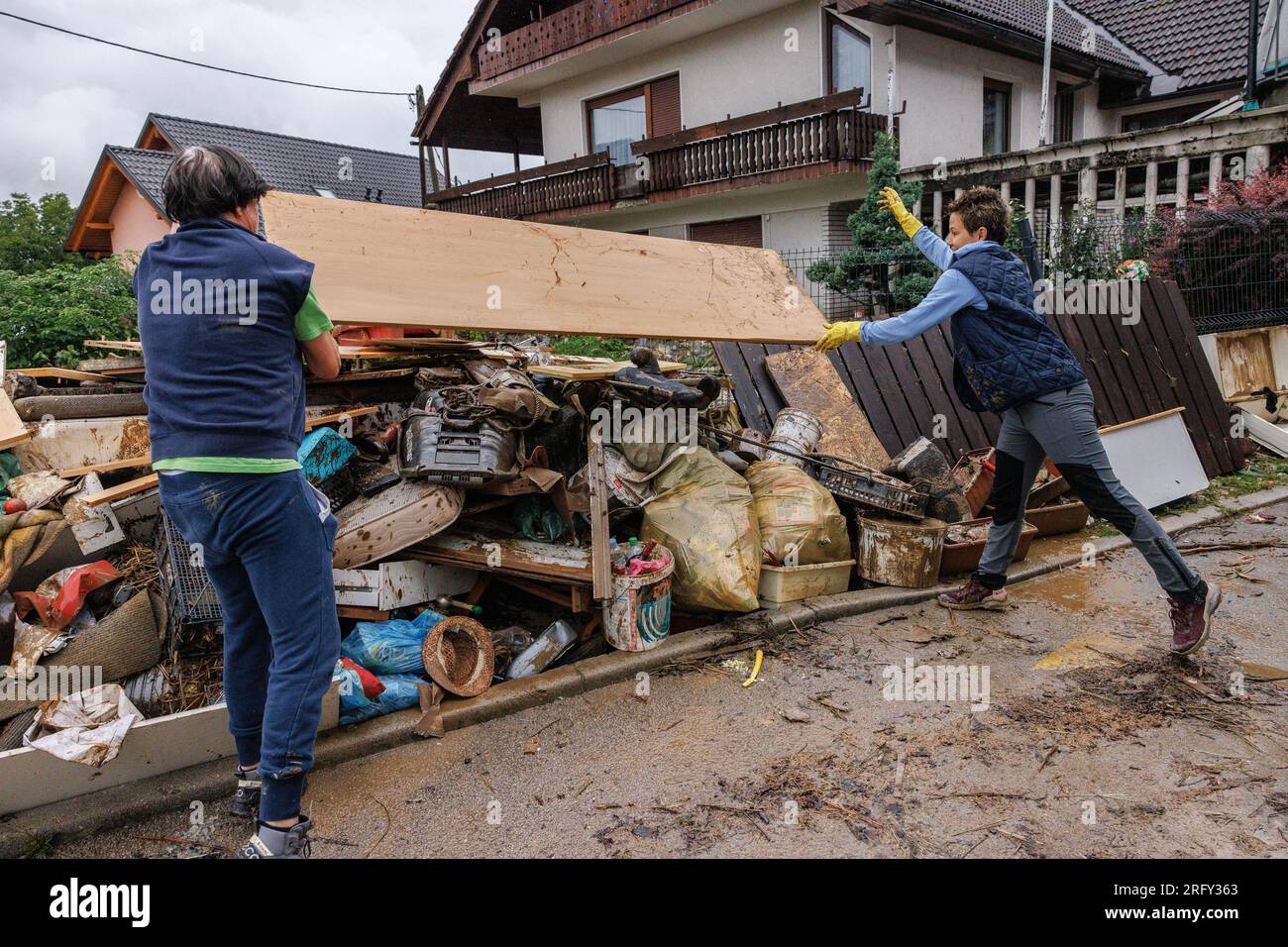 People dispose damaged furniture as they clean their flood-damaged ...