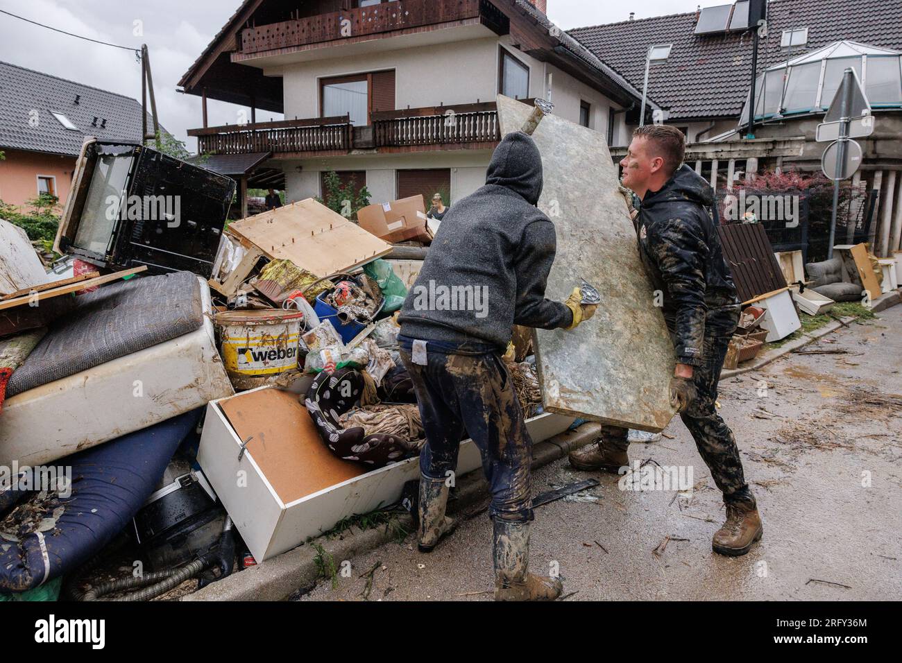 People dispose damaged furniture as they clean their flood-damaged ...