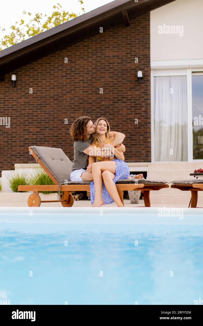 Handsome young couple relaxing by the swimming pool in the house backyard Stock Photo - Alamy