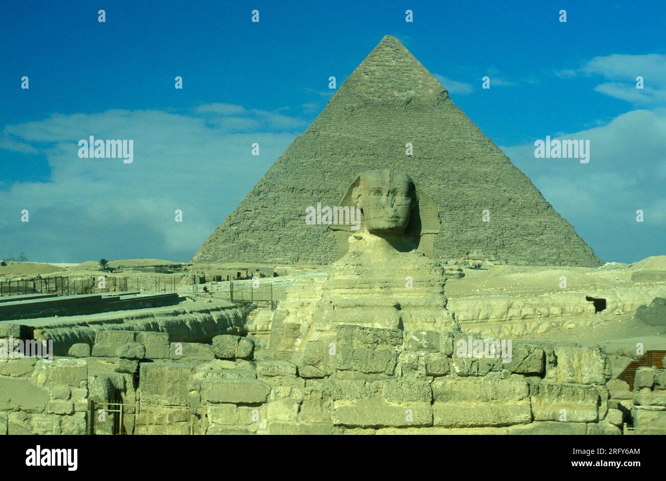 the monument of Sphinx in front of pyramids of giza near the city of ...