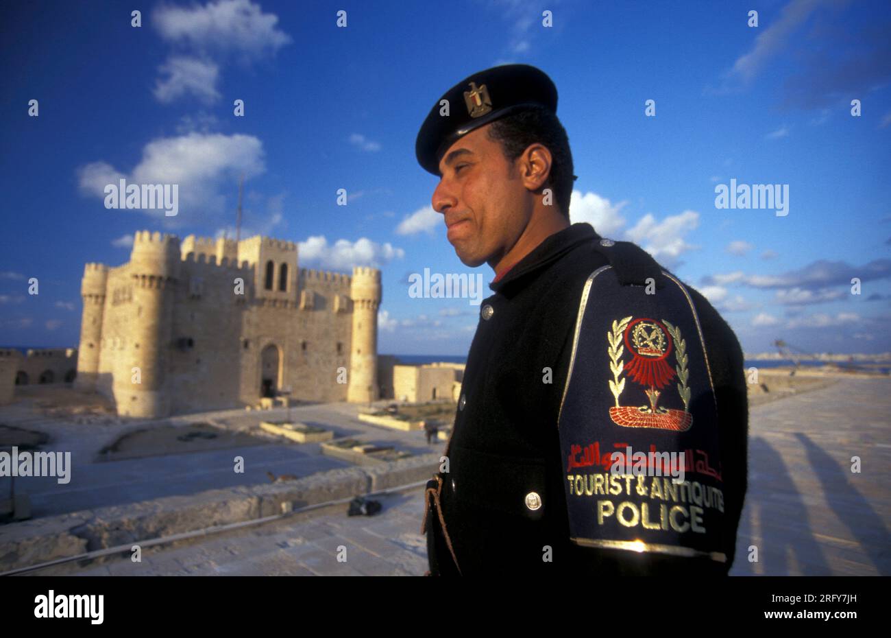 a police men in front of the Citadel and Fort Qaitbey at the Al ...