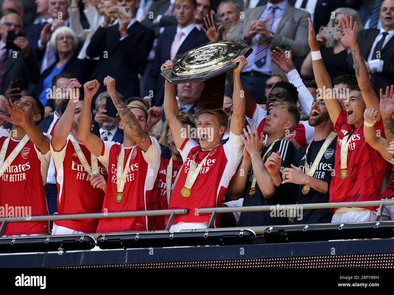 Arsenal's Martin Odegaard (centre) and team-mates lift the trophy after ...