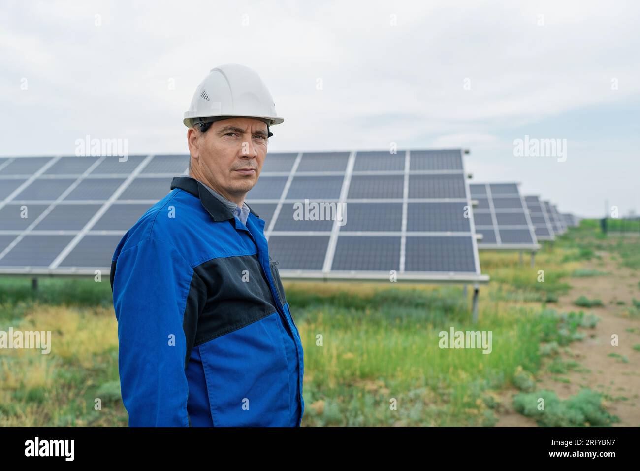Service Engineer man standing in front of solar panels. Technician maintenance solar cells on ...