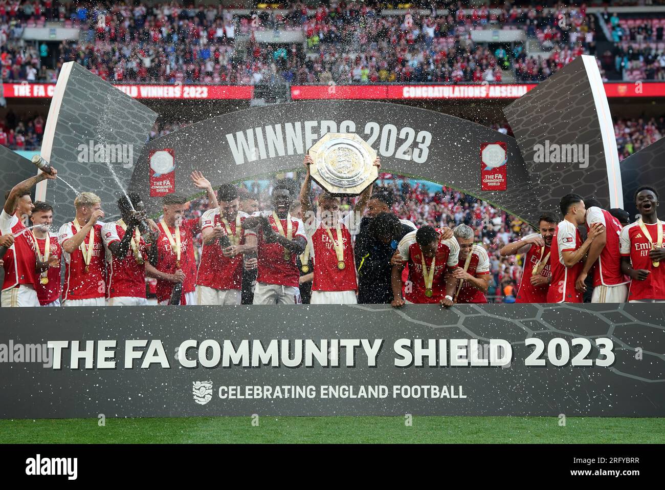 Arsenal's Martin Odegaard (centre) and team-mates lift the trophy after ...