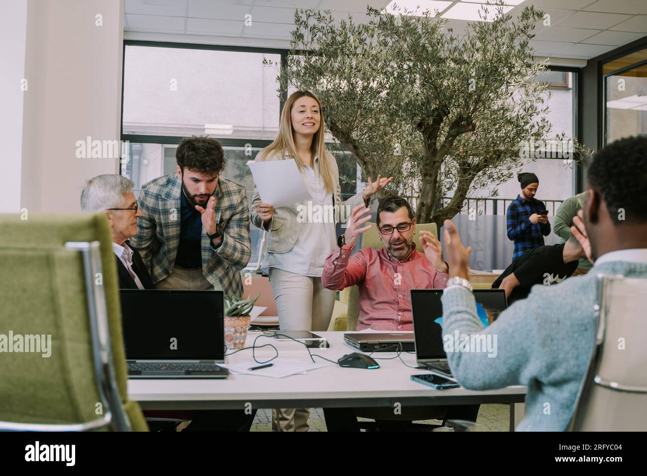 Four employees at the office arguing about the latest client on the ...