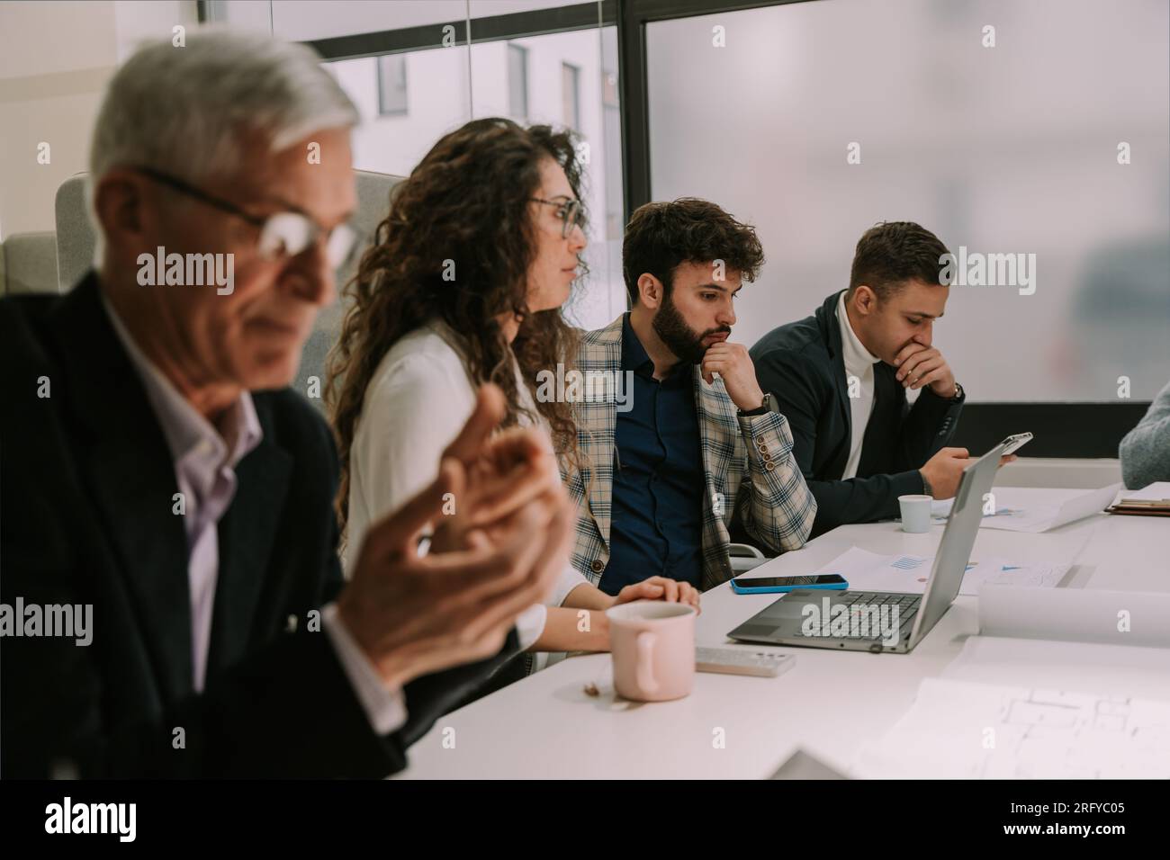 Multi-generational group of people waiting for the meeting to start ...