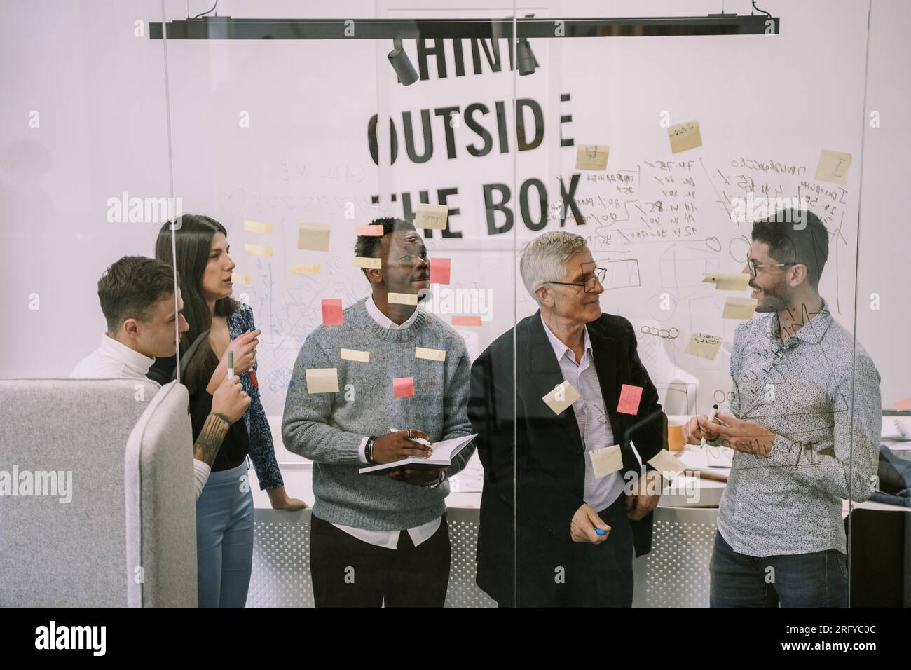 Multi-generational group of people working together at modern co ...