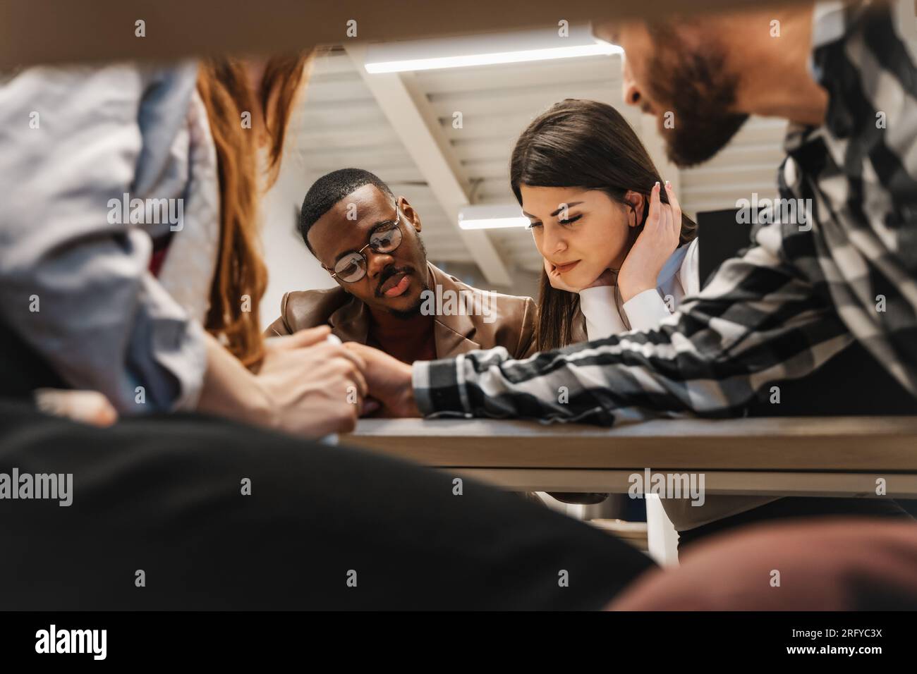 A group of young multiracial employees working together at the ...