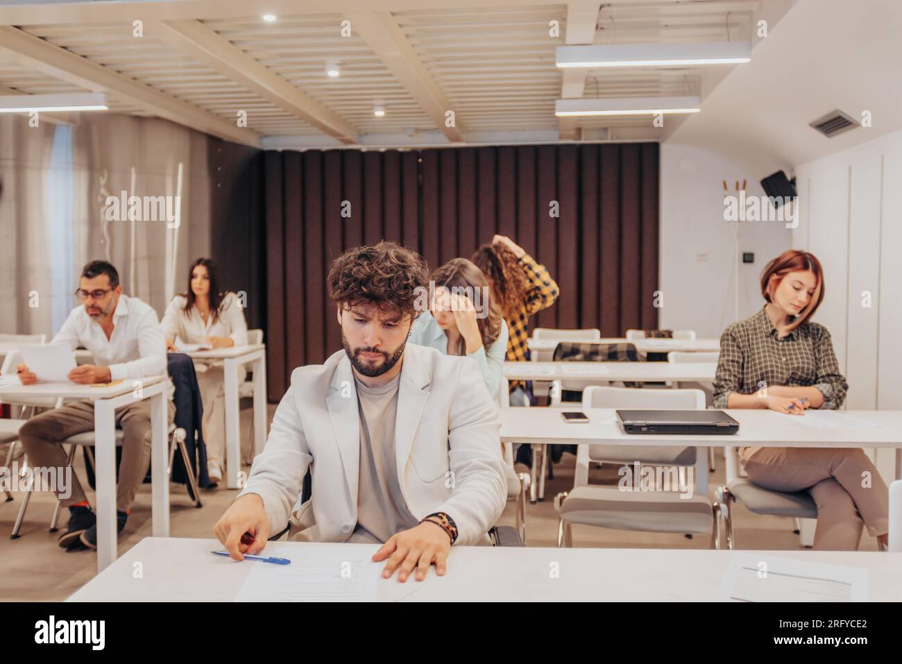 Front photo of different-aged people having exam after business ...