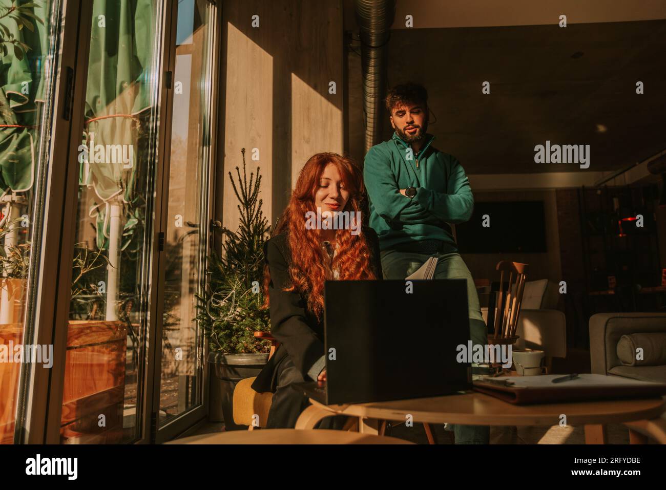 Low angle view of ginger woman working on her lap top while her male ...