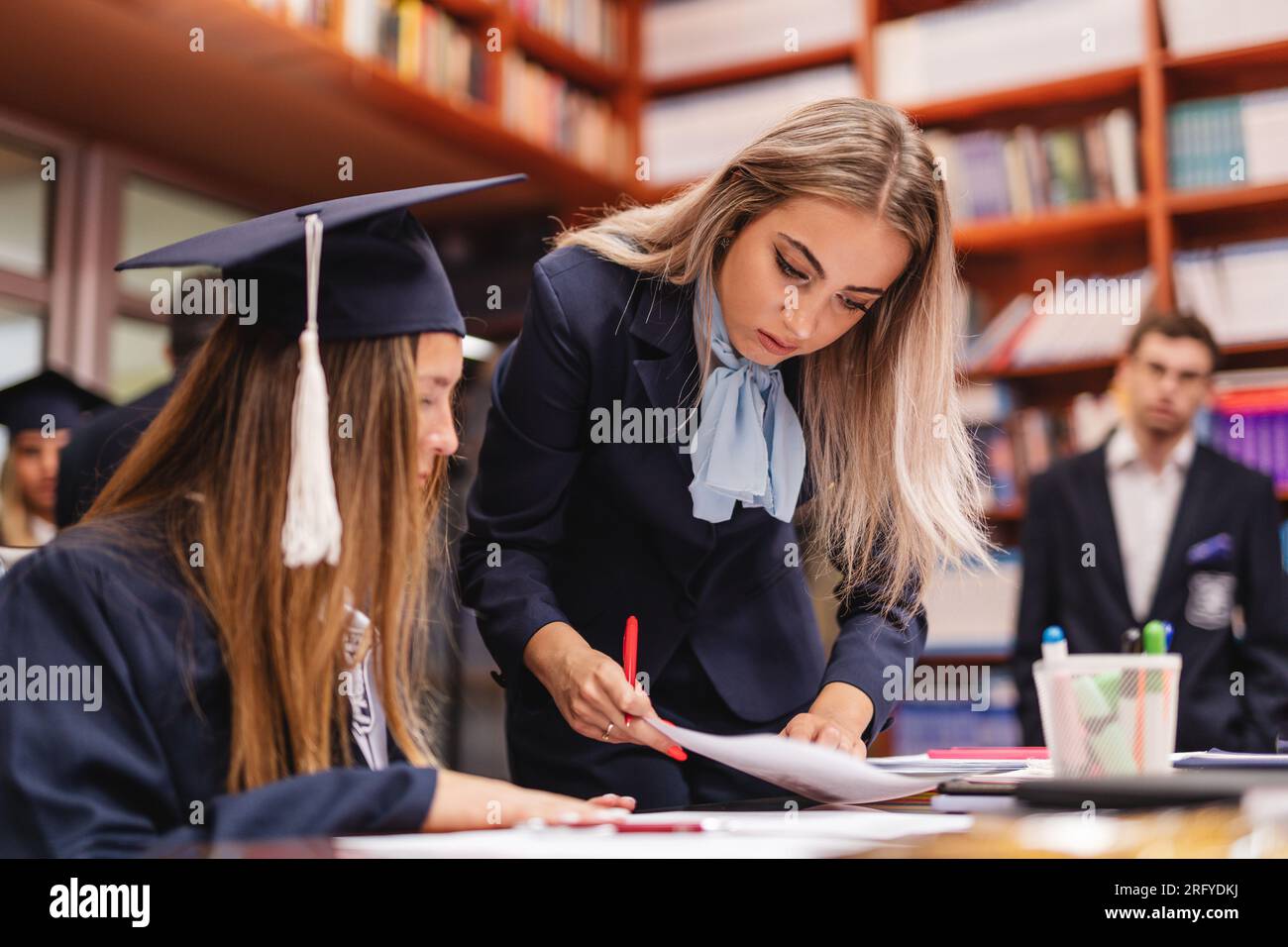 Student is helping his classmates at the library Stock Photo - Alamy