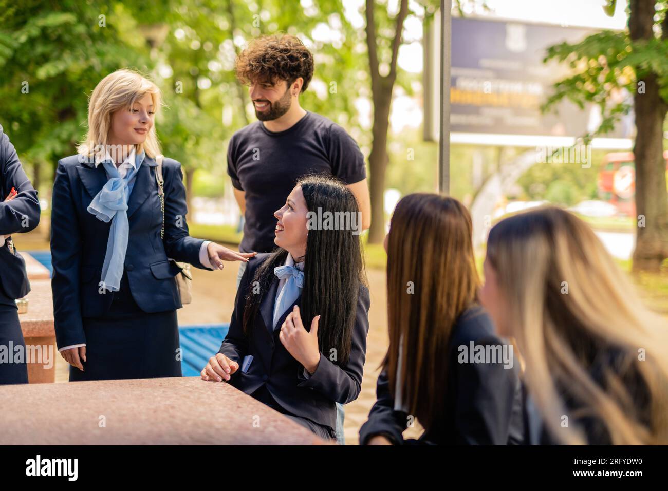 Group of young students in uniform having a meeting with the mentor ...