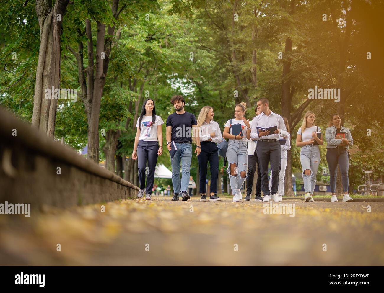 Low-angle of high school students walking together with books in their ...