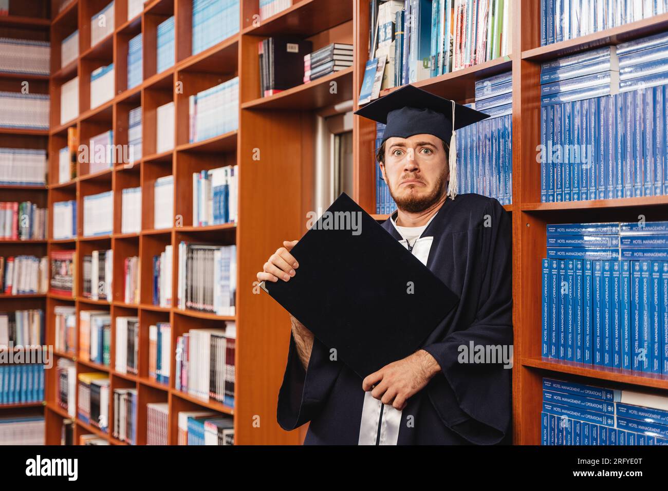 Sad college graduate holding diploma hi-res stock photography and ...