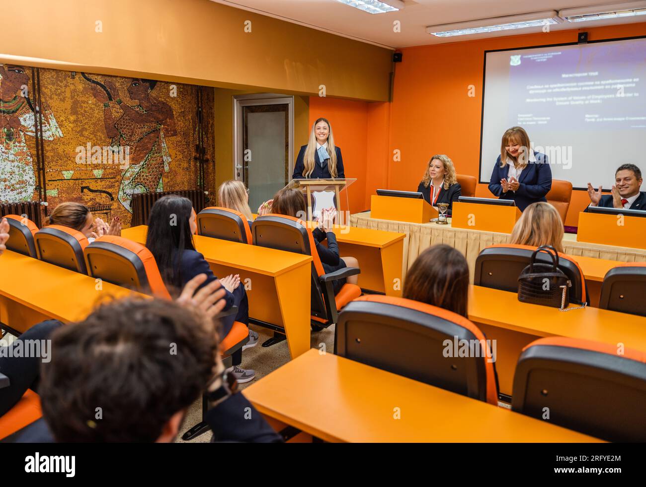 Professors and students applauding their classmate after giving a ...